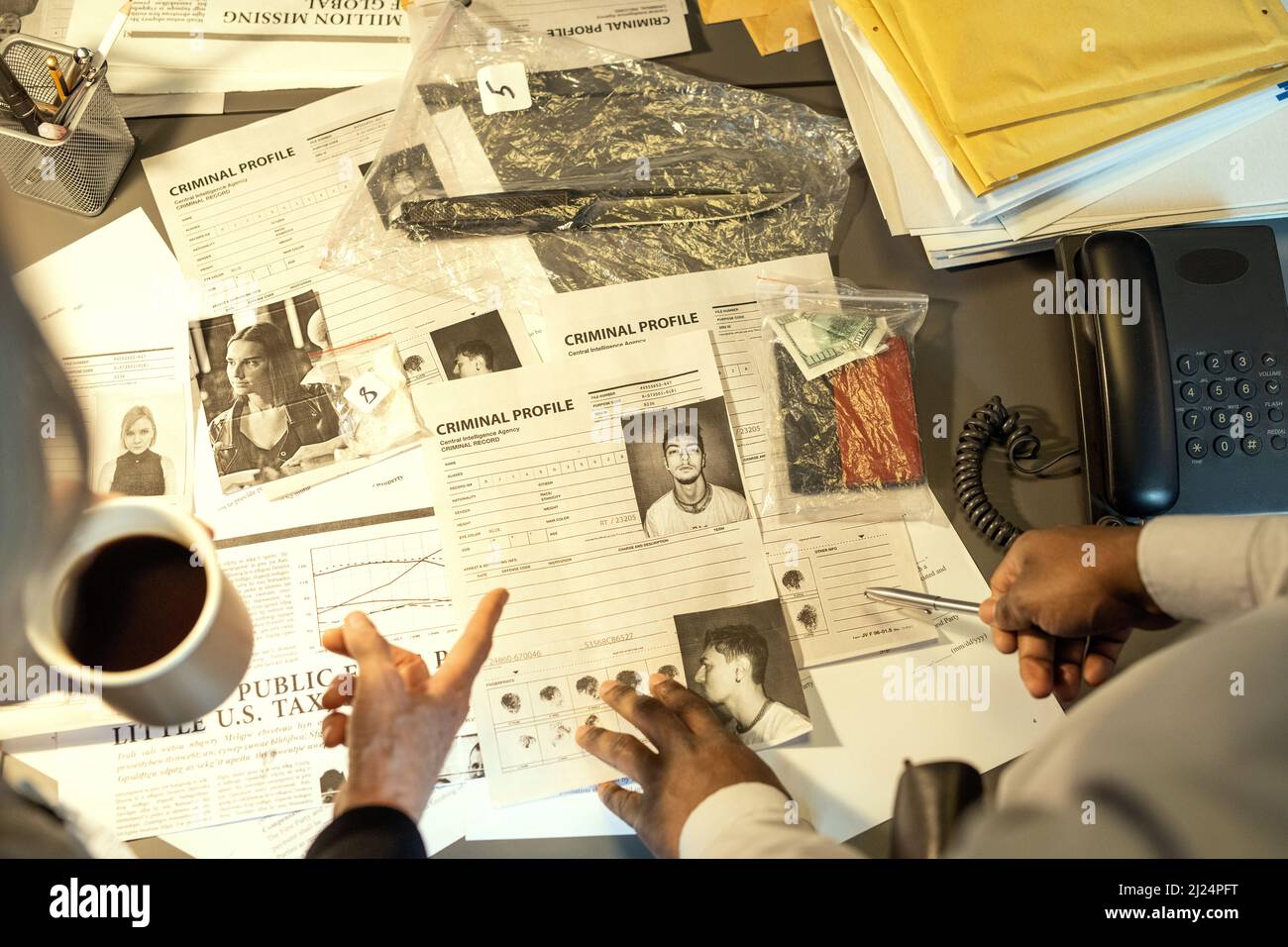 Hands of two interracial FBI agents pointing at profile of one of ...