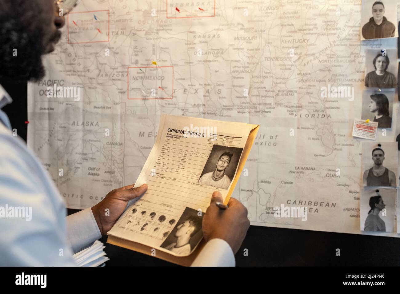 Young African American male FBI agent looking through criminal profile ...