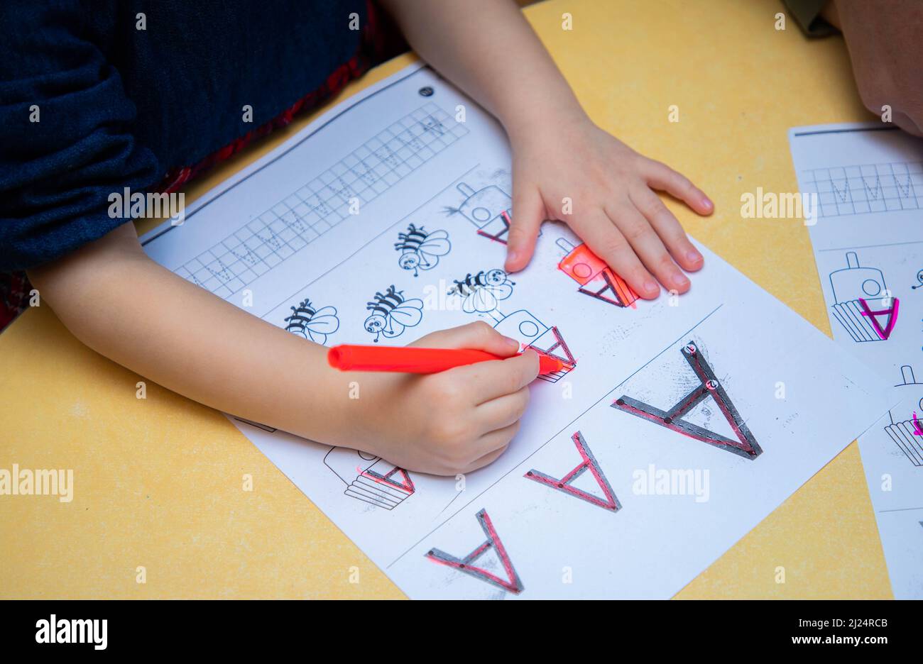 The hands of a child of European appearance write and circle the ...