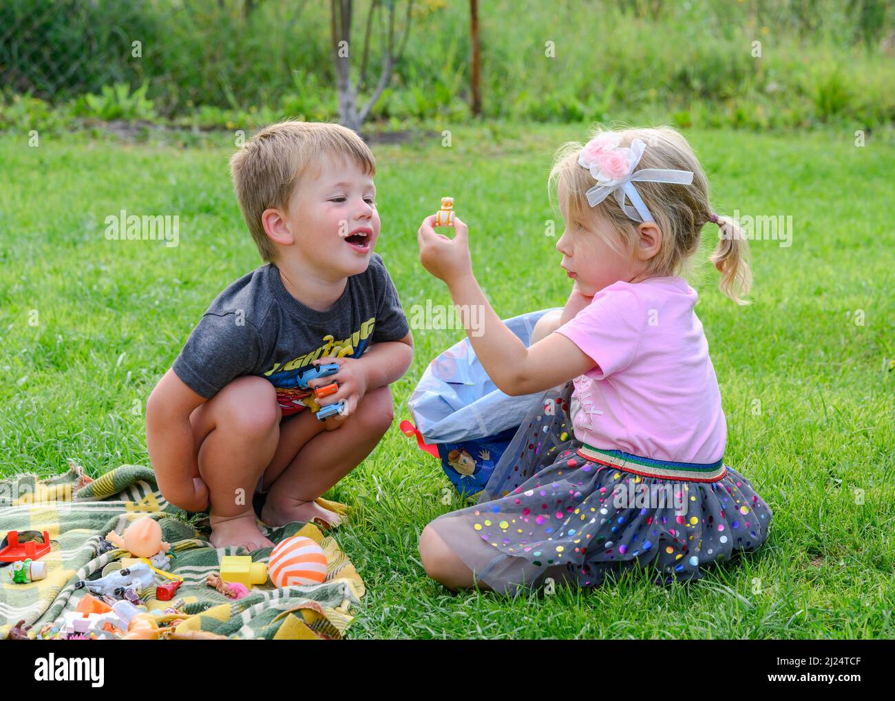 Little boy and girl play on the lawn with toys, solving riddles Stock ...