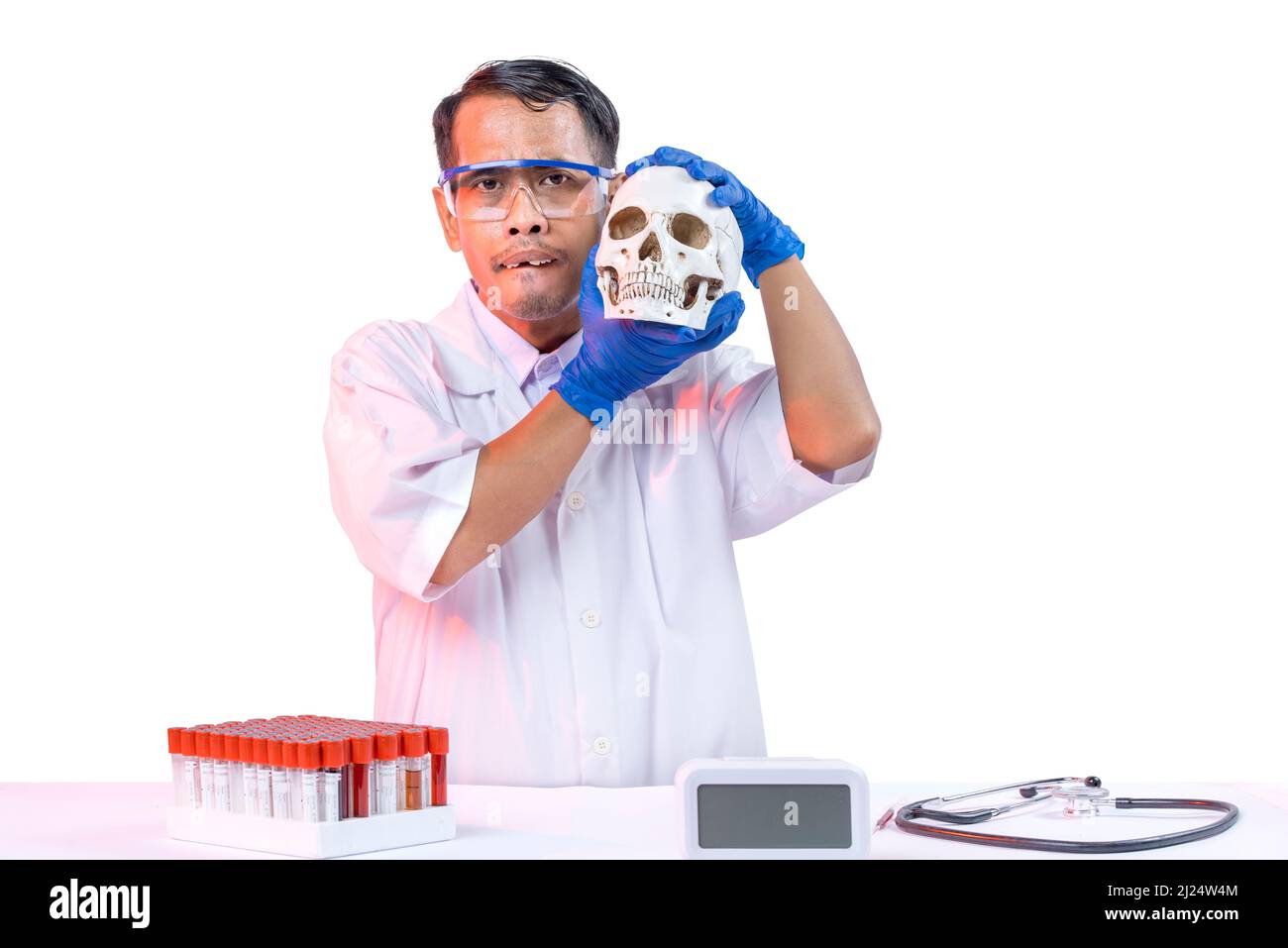 Asian nerd scientist standing and holding a skull head with a ...