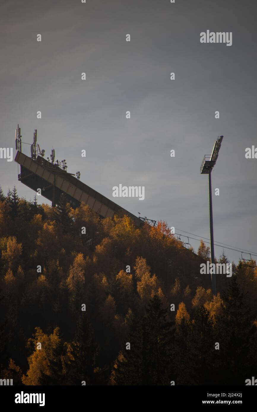 A vertical shot of Harrachov springboard between trees in Czech ...
