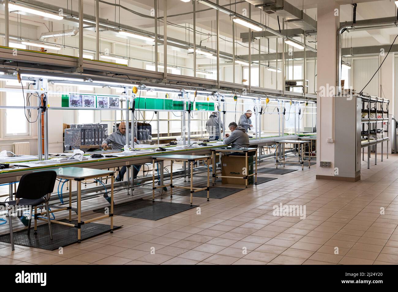 Photo of a plant for assembling monoblocks for computers. Working men ...