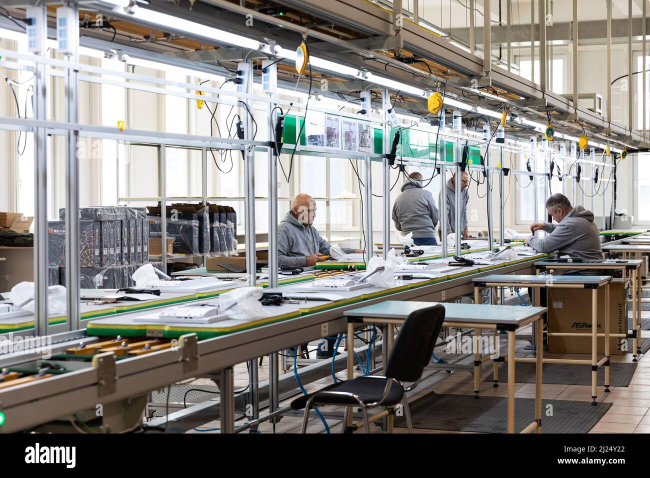 Photo of a plant for assembling monoblocks for computers. Working men ...