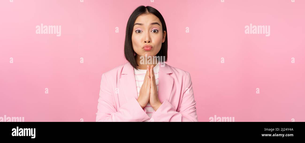 Portrait of asian businesswoman asking for help, say please, standing ...