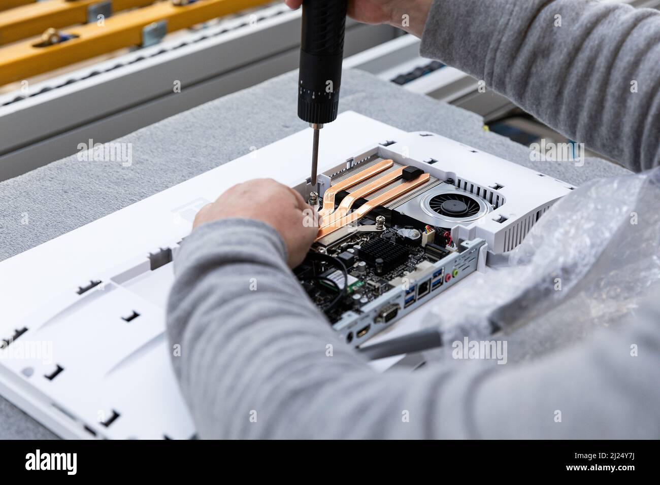 Photo of hands of a man who assembles a computer monitor system block ...