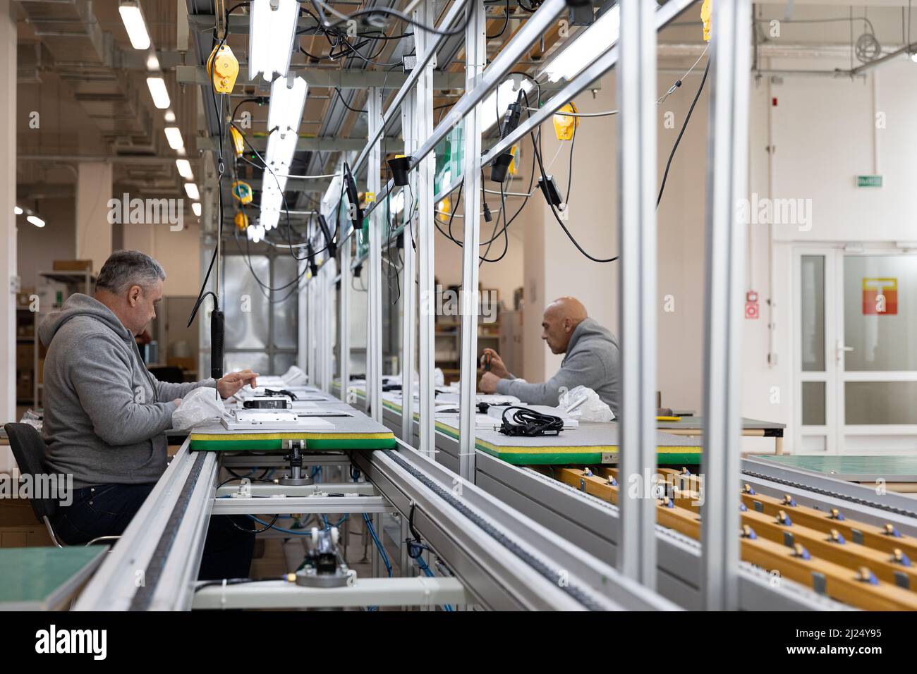 Photo of a plant for assembling monoblocks for computers. Working men ...