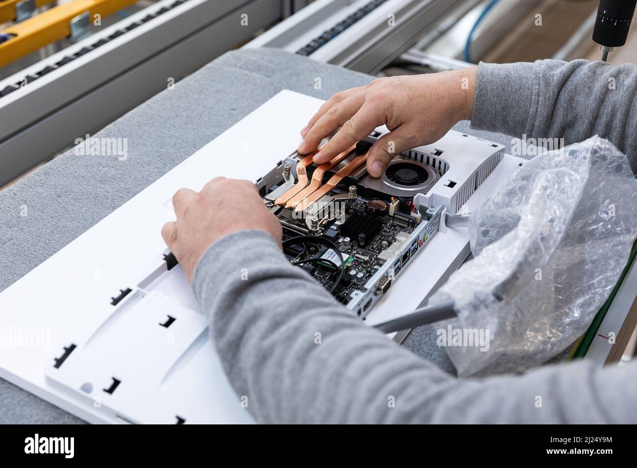 Photo of hands of man who assembles a computer monitor system block on ...