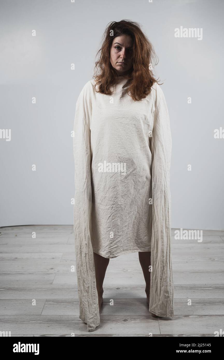 Close-up portrait of insane woman in straitjacket on white background ...