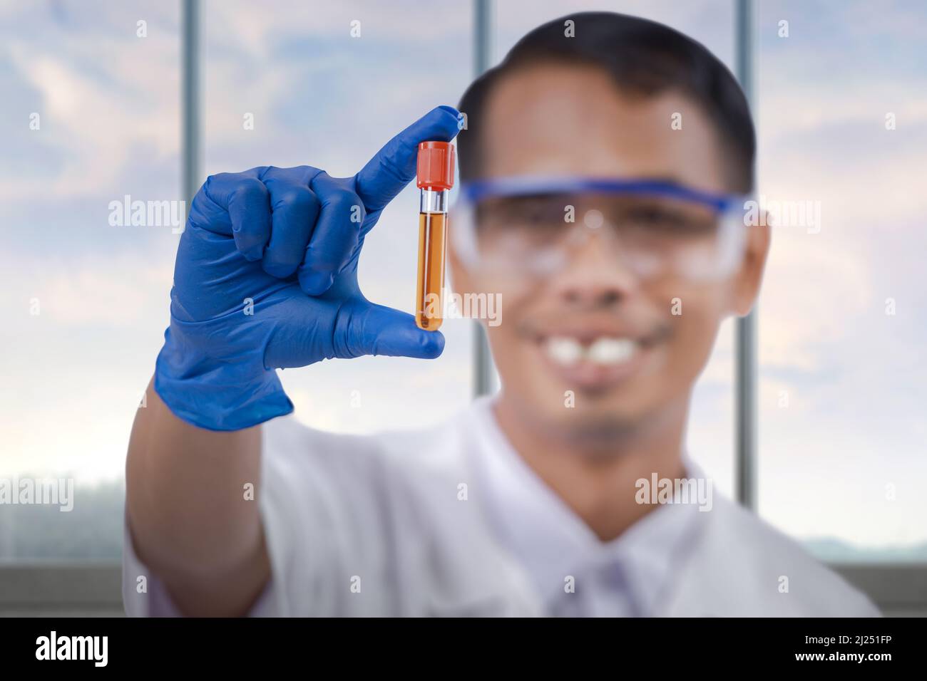 Asian nerd scientist holding a sample tube in the laboratory Stock ...