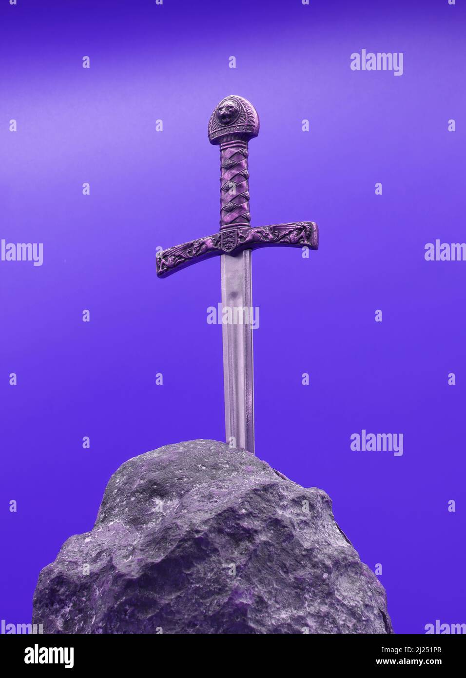 Excalibur, the mythical sword in the stone of King Arthur on purple ...
