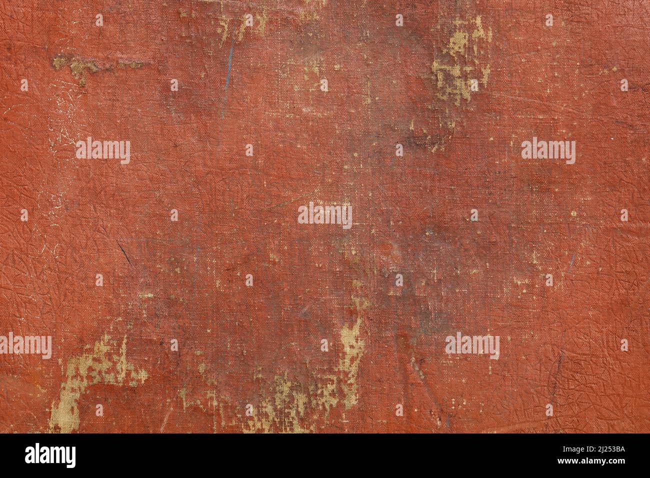 Close up grunge uneven old weathered red and brown daub plaster wall ...