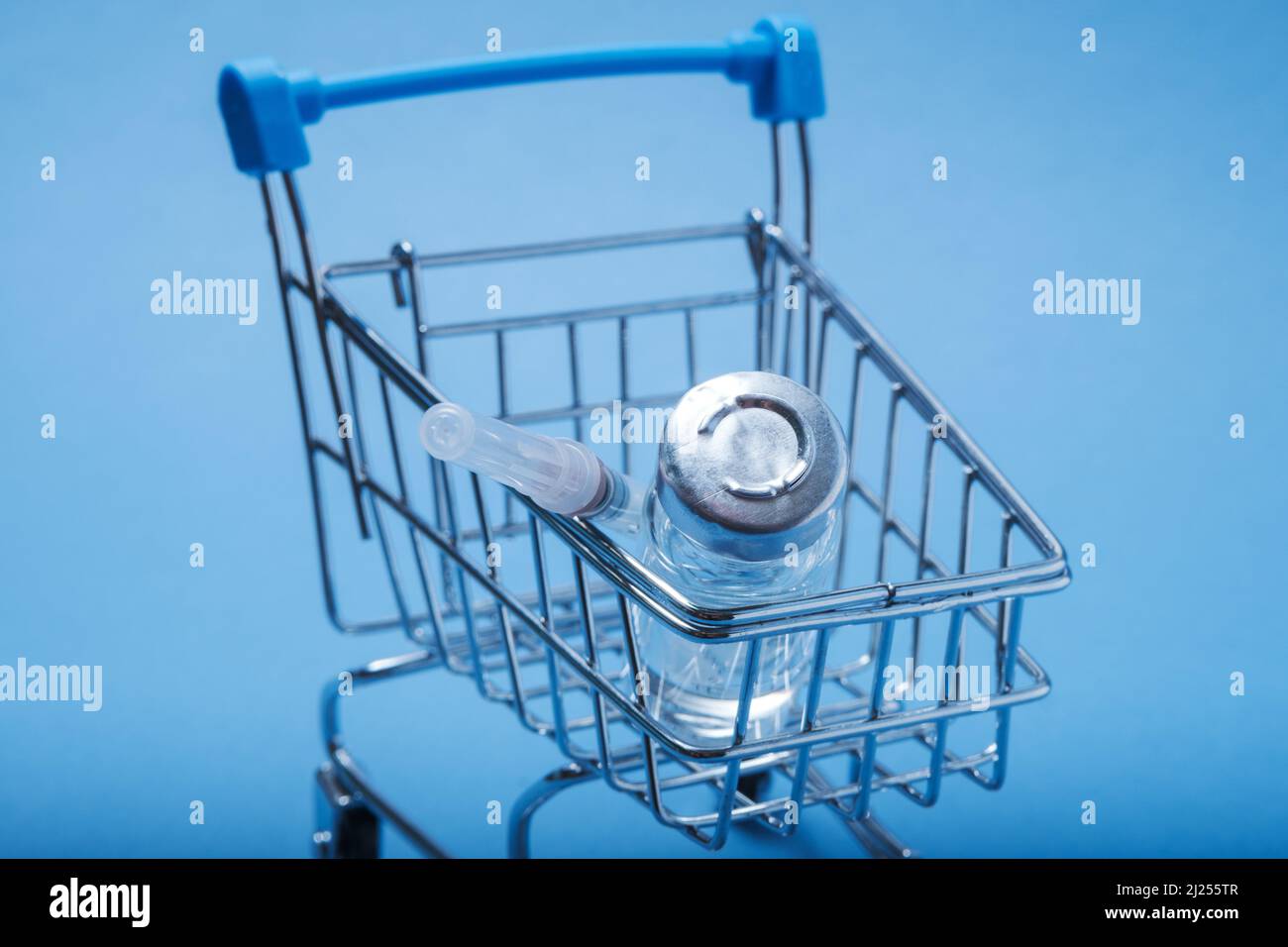Basket with a syringe and an ampoule on a blue background Stock Photo ...