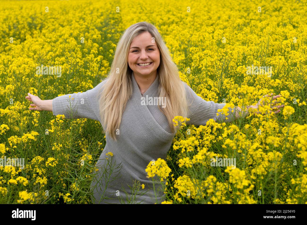 Young woman suffers from allergy, hay fever and pollen in a rape field ...