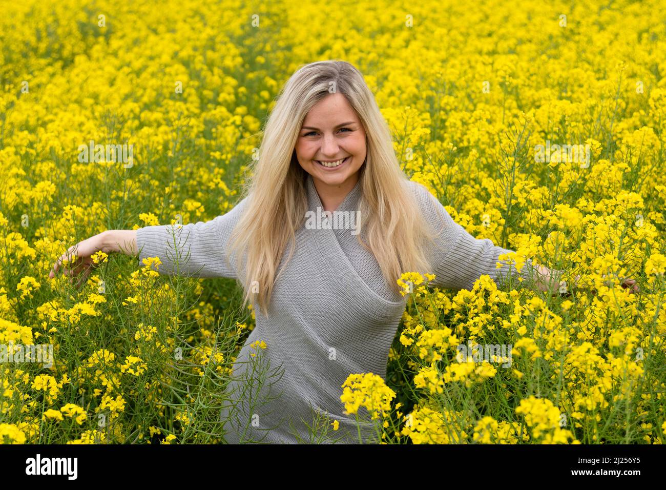 Young woman suffers from allergy, hay fever and pollen in a rape field ...
