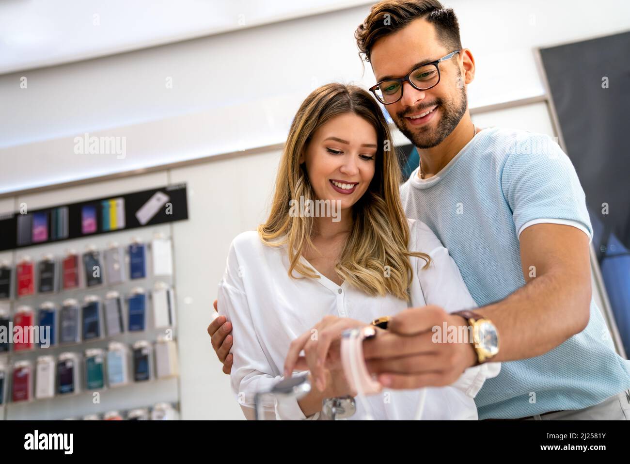 Happy young people buying new digital gadgets in store. Tecgnology ...