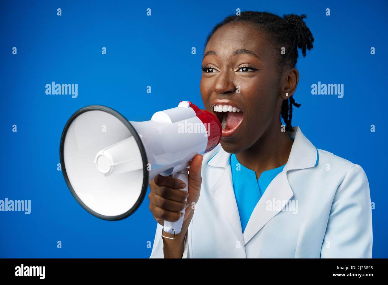 Afro american female doctor in white medical gown scream in megaphone ...