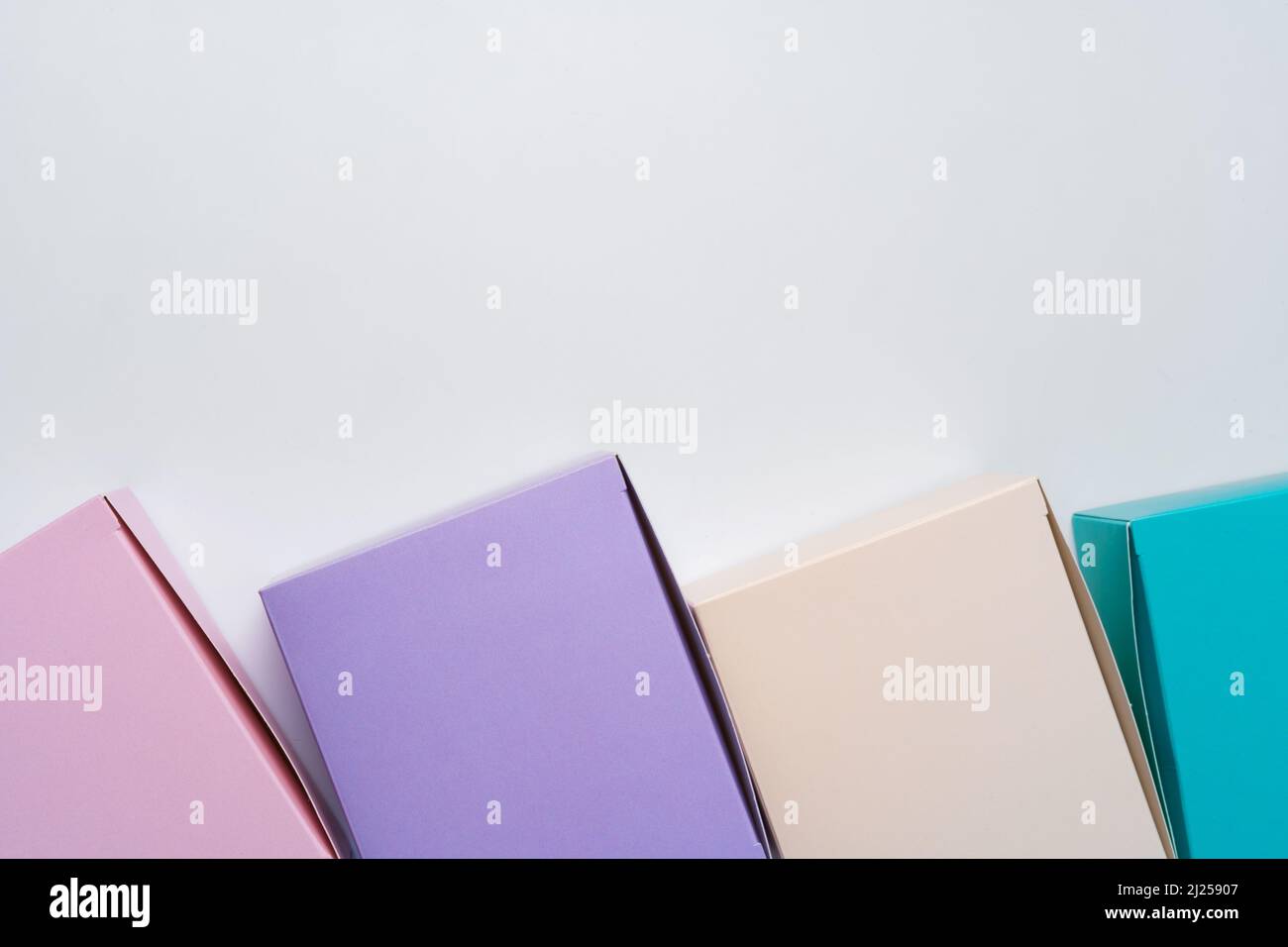 Pile of colorful cardboard boxes on white background Stock Photo - Alamy