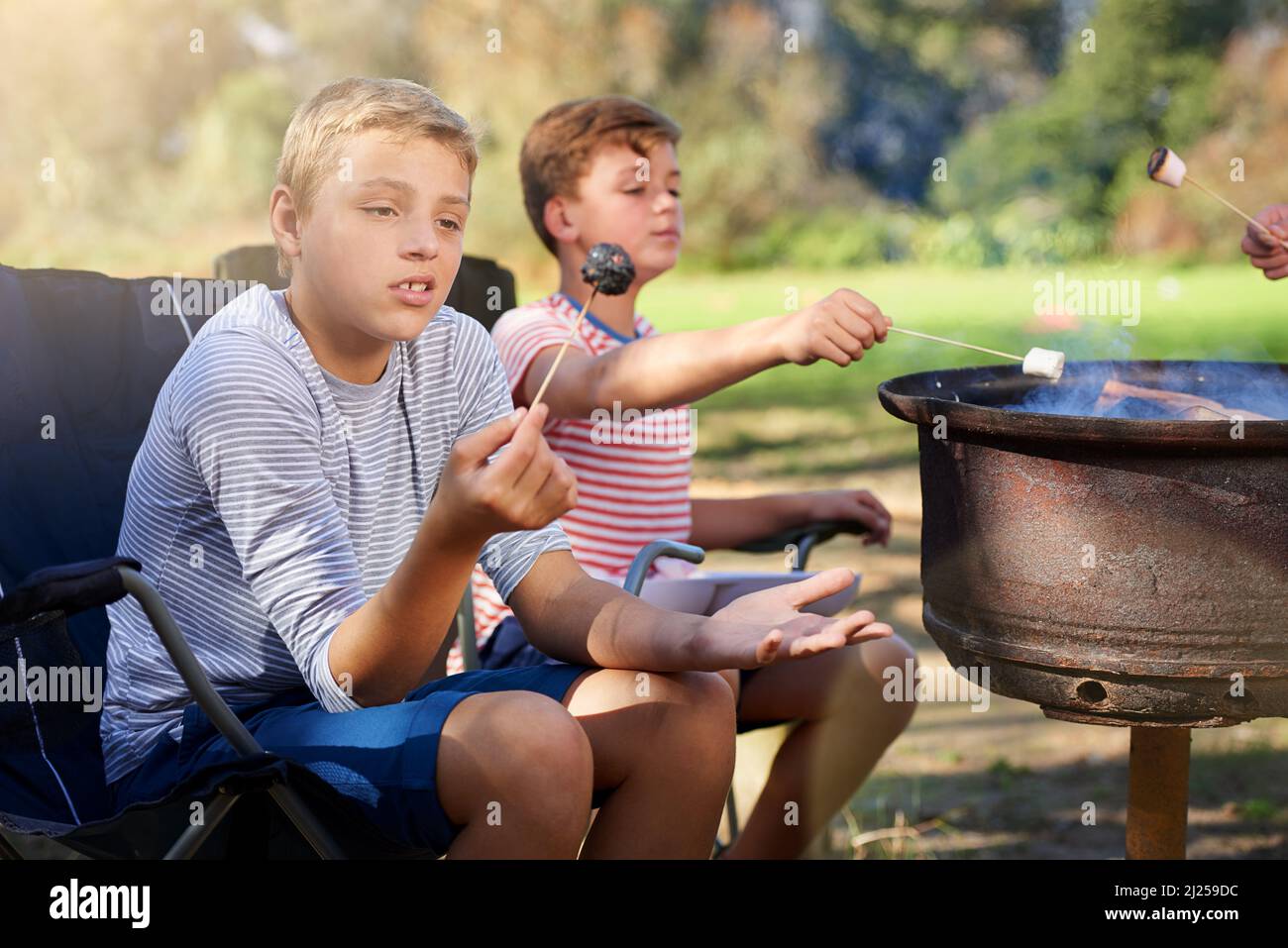 Fail.... A young boy looking disappointed after burning his marshmallow ...