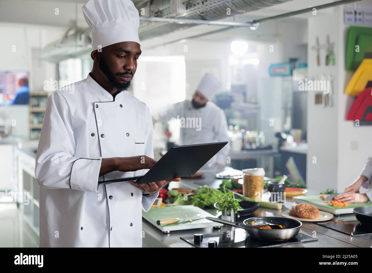 Gourmet cuisine head chef with laptop looking for gastronomic dish ...