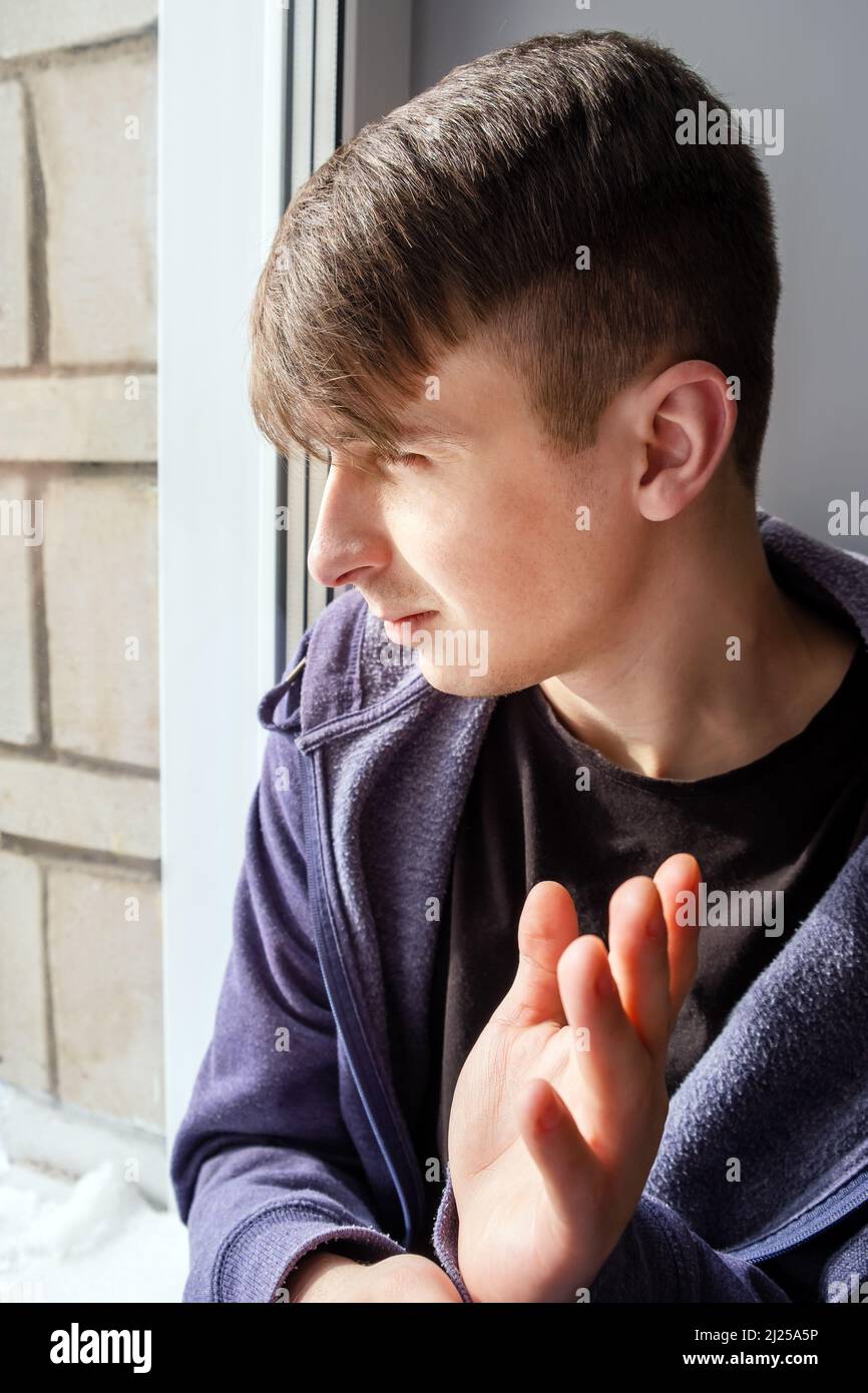 Young Man sit by the Window in the Room Stock Photo - Alamy