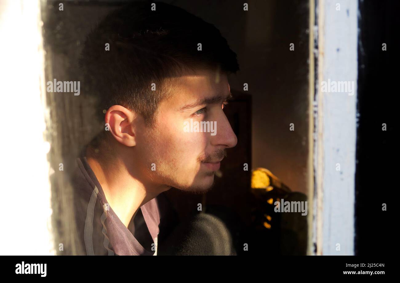 Man looking through window house sad hi-res stock photography and ...
