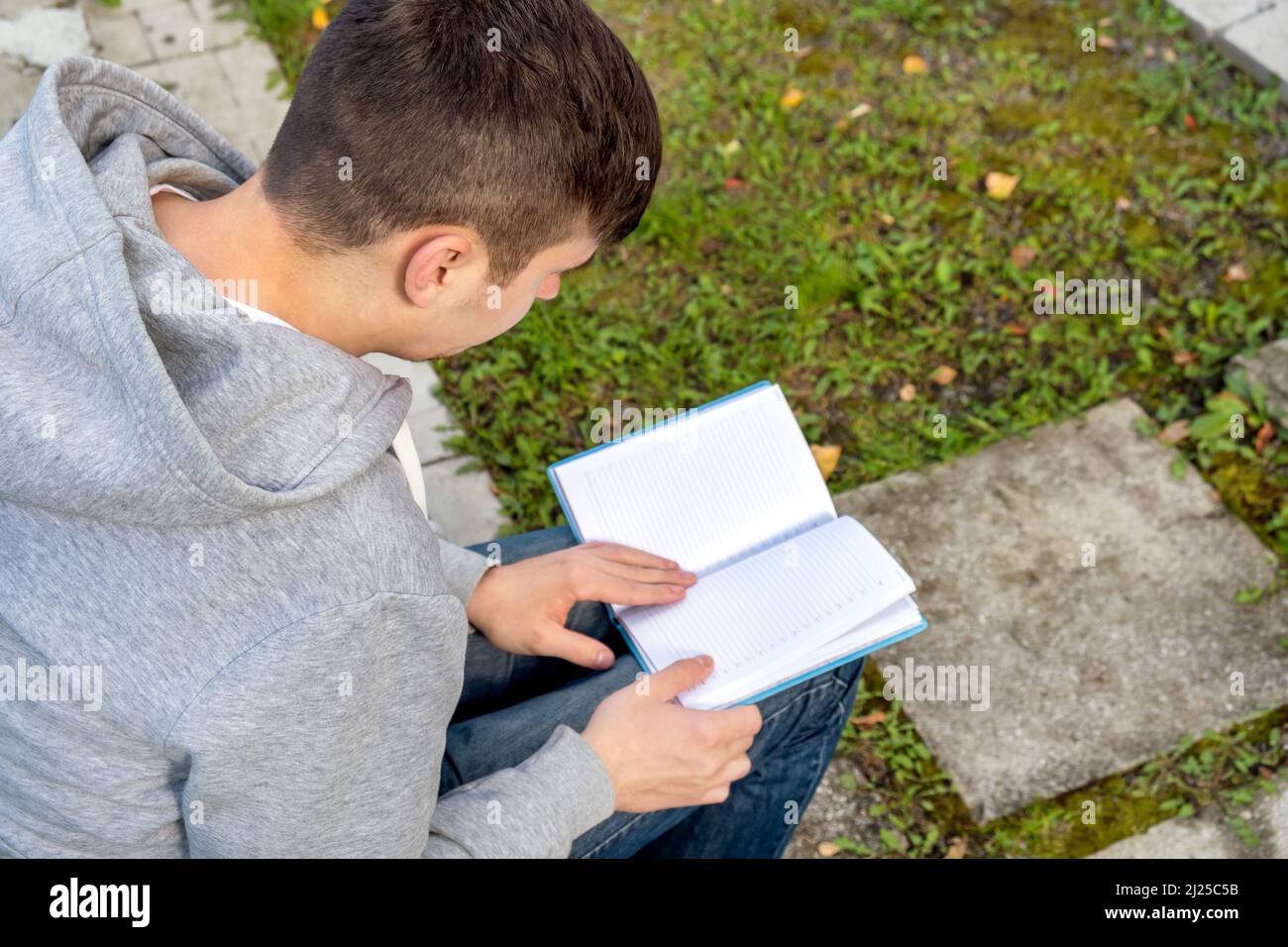 Young Man read a Book at the Summer Street Stock Photo - Alamy