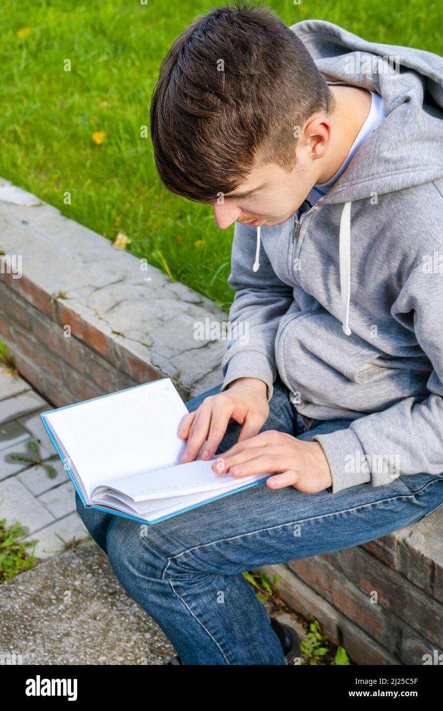 Young Man read a Book at the Summer Street Stock Photo - Alamy