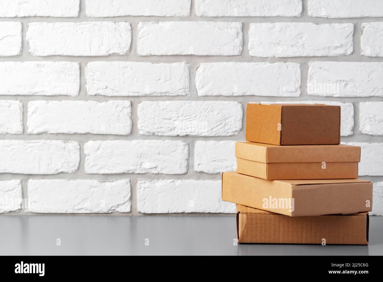 Cardboard boxes against white brick wall, close up Stock Photo - Alamy
