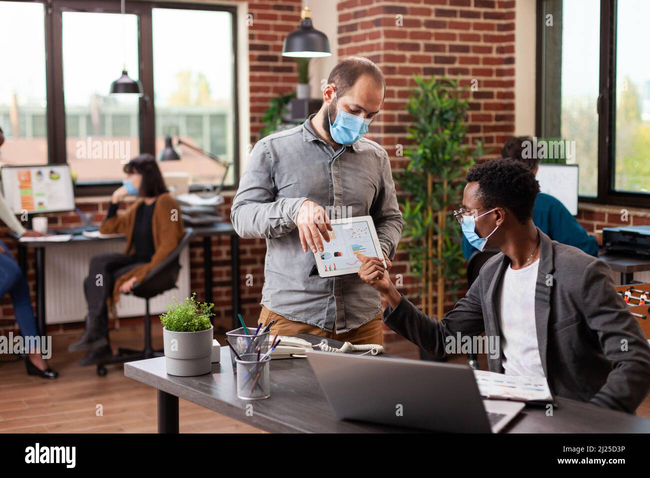 Multiracial businessmen comparing marketing statistics discussing ...