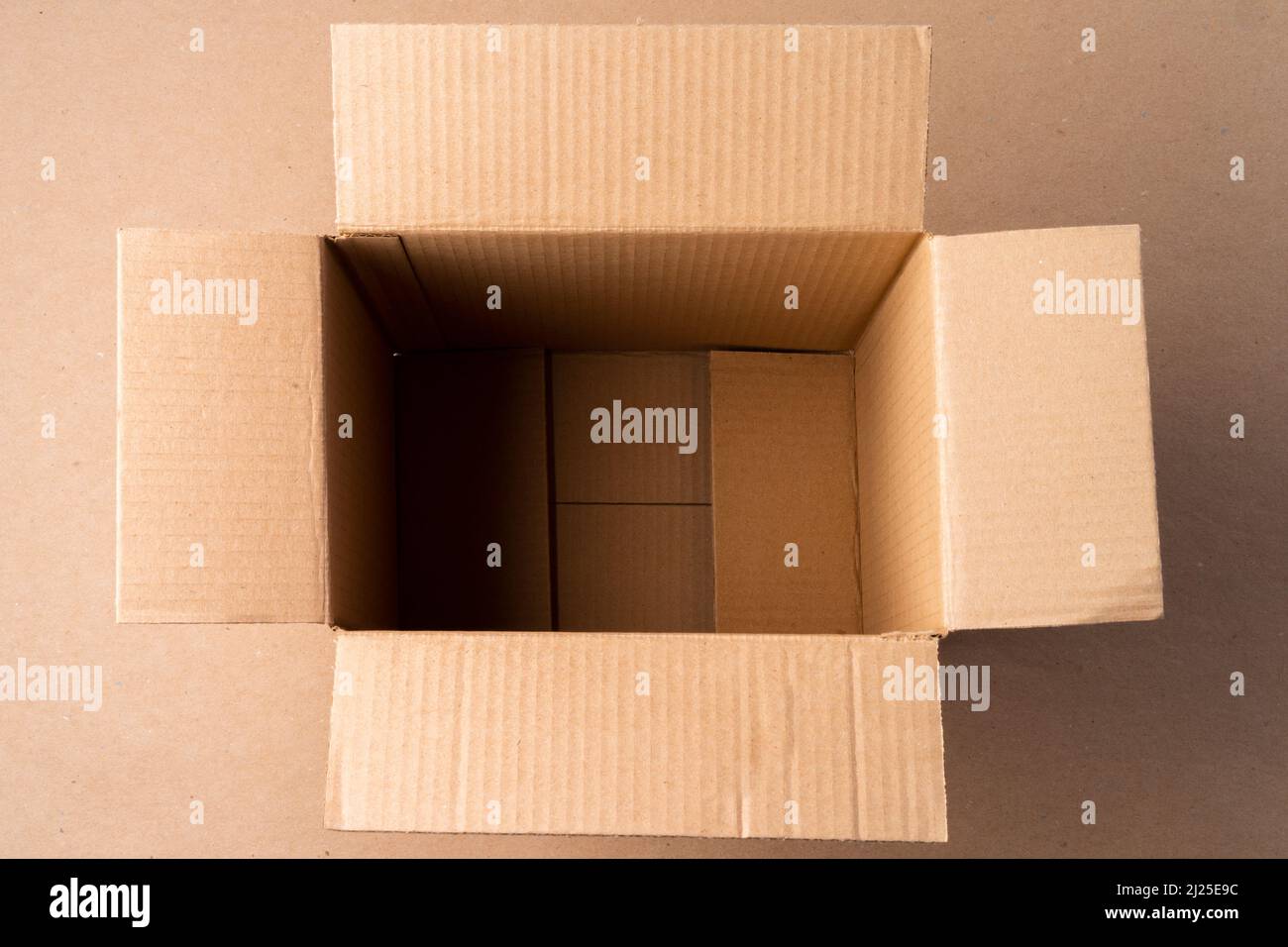 Cardboard box on beige background in studio Stock Photo - Alamy