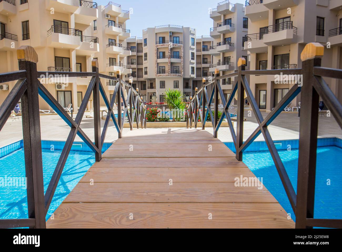 Large swimming pool with wooden bridge at a luxury tropical apartment ...