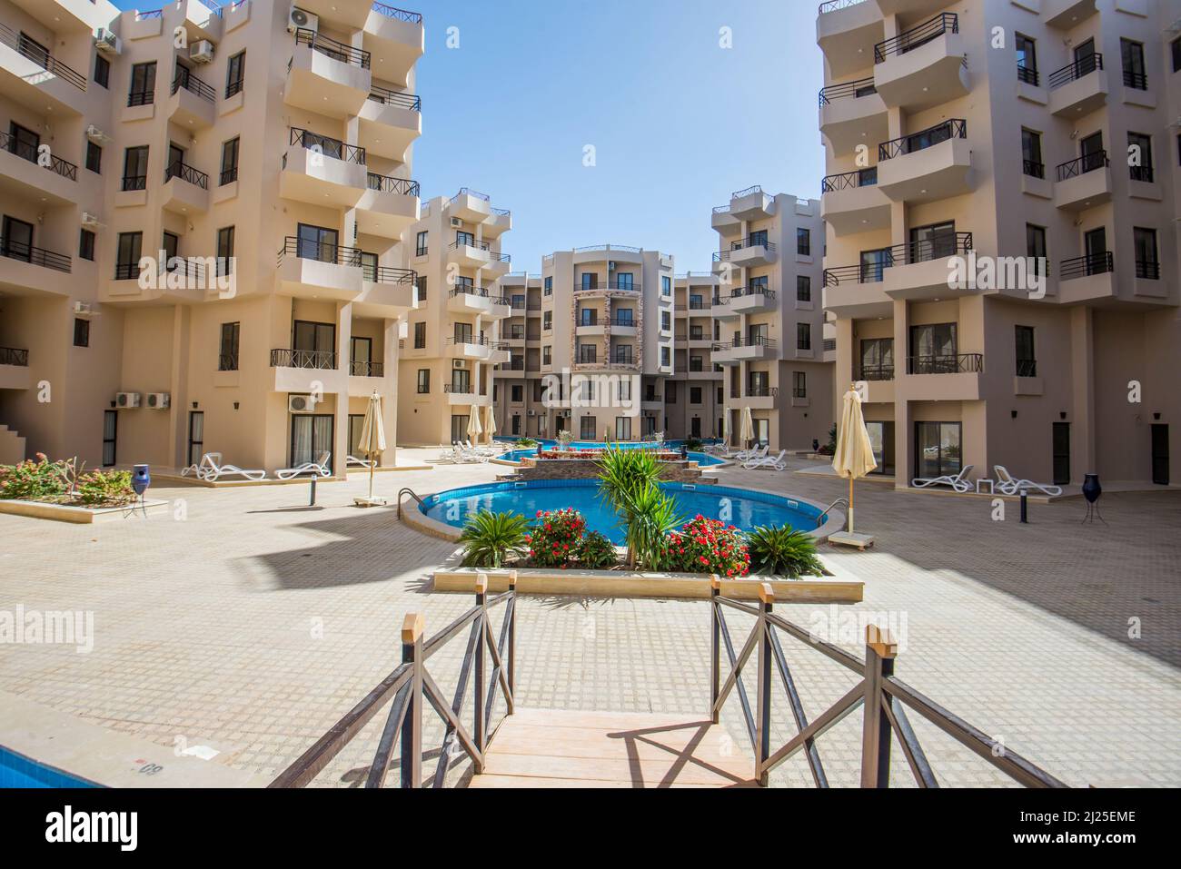Large swimming pool with wooden bridge at a luxury tropical apartment ...