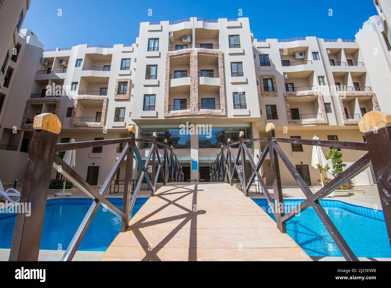 Large swimming pool with wooden bridge at a luxury tropical apartment ...