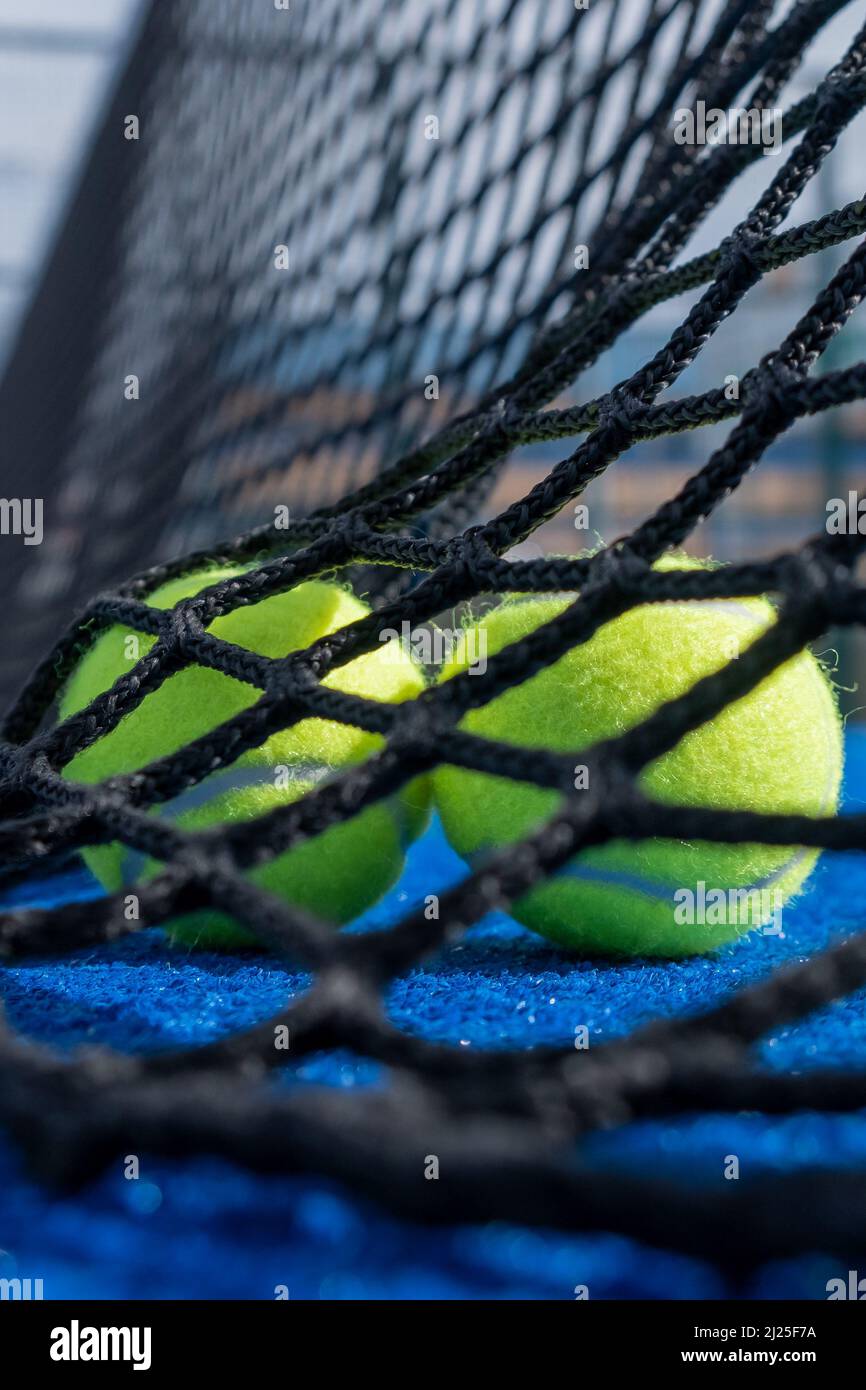 selective approach, two paddle tennis balls behind the net of a blue ...