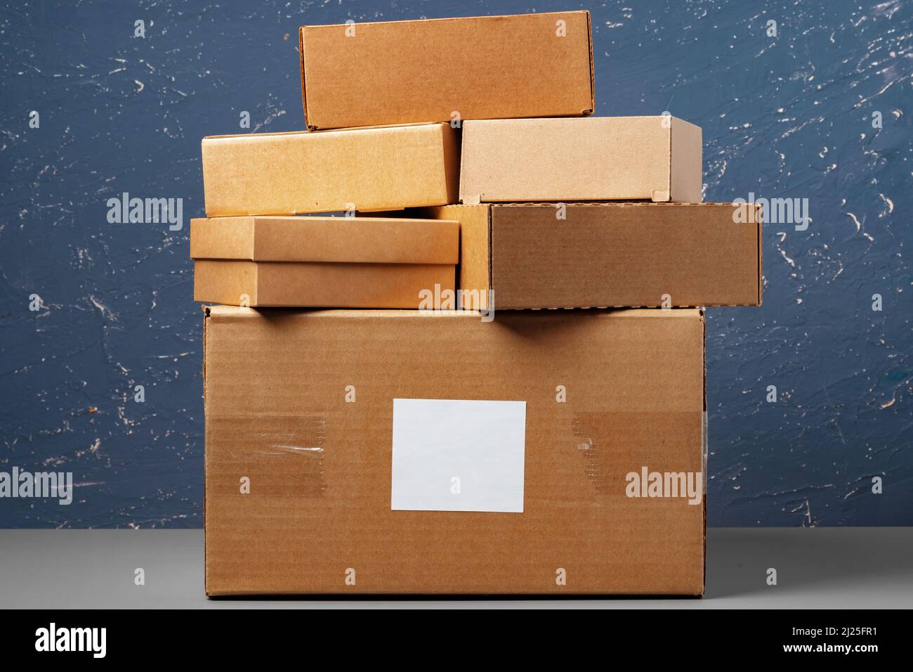 Group of cardboard boxes against blue background Stock Photo - Alamy