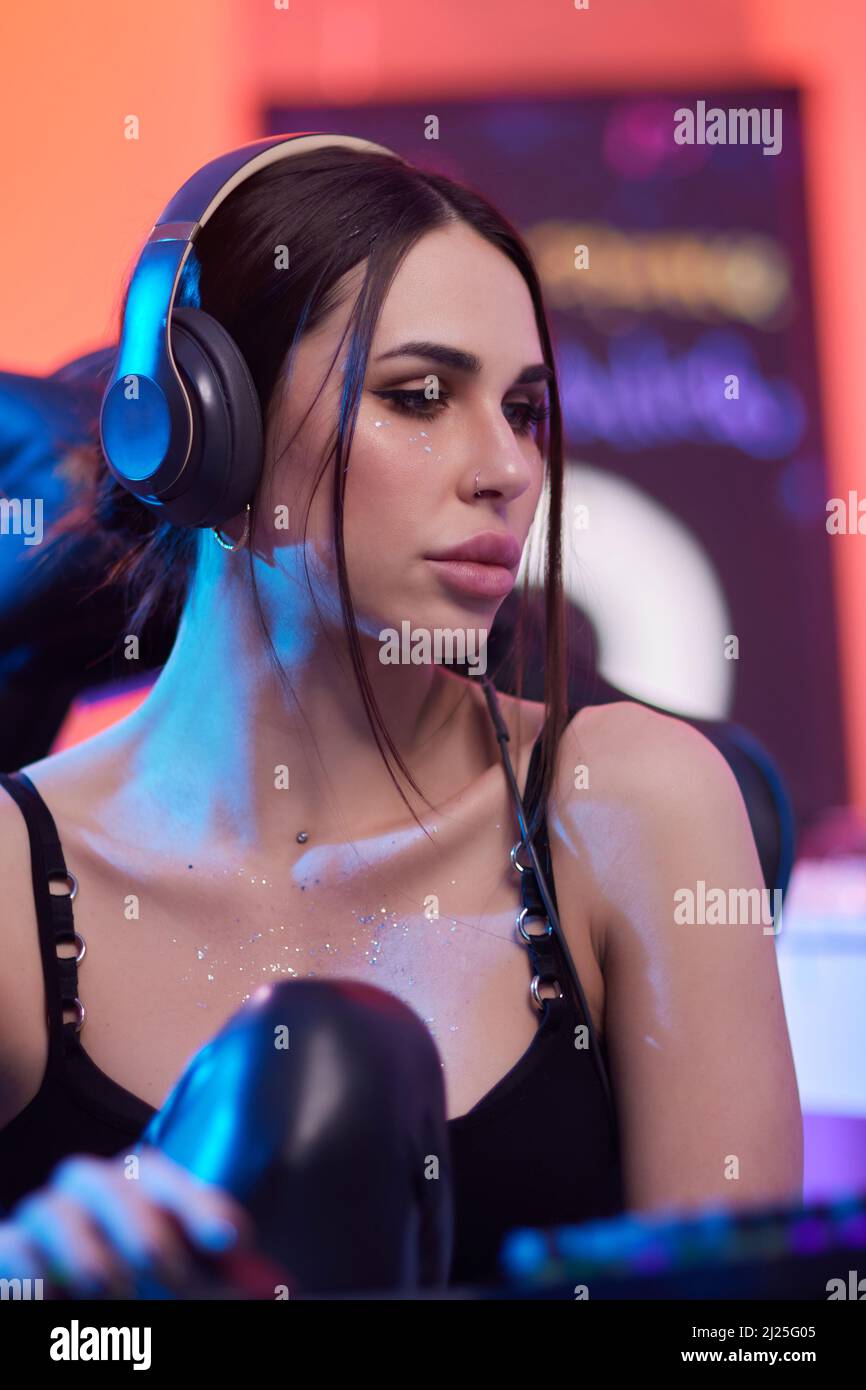 Happy woman putting on headphones and playing computer game. Female ...