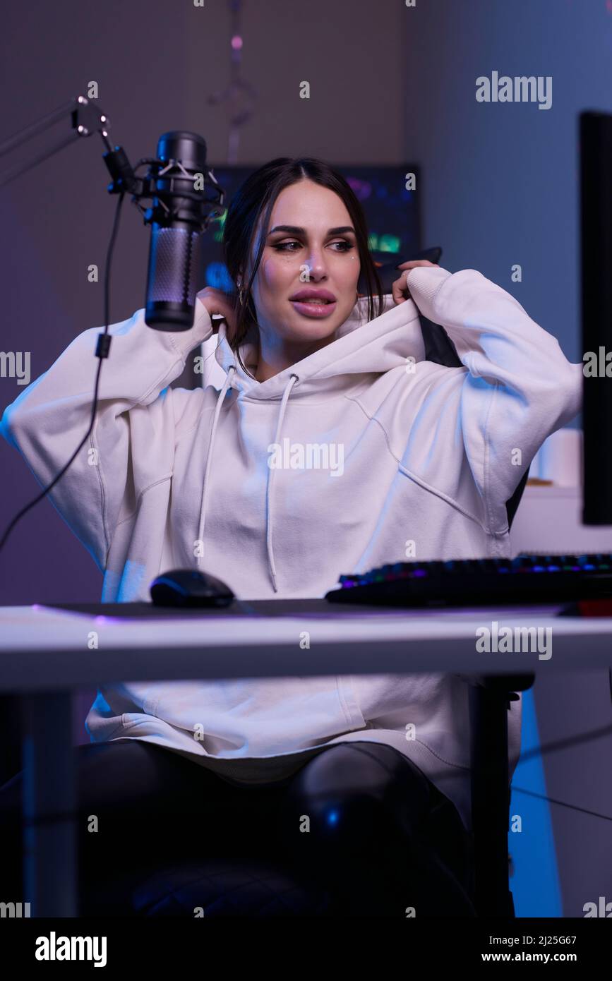 Happy woman putting on headphones and playing computer game. Female ...