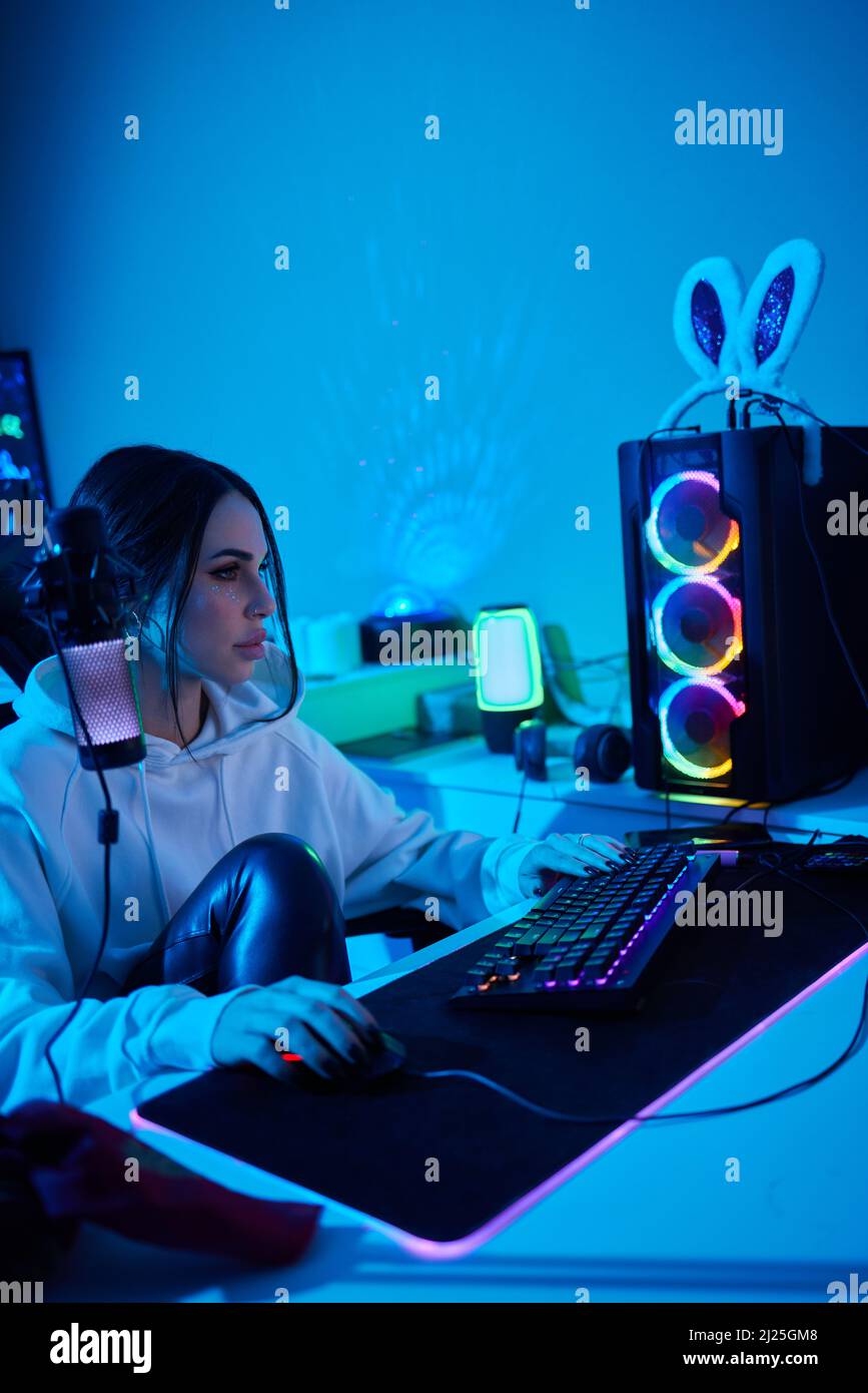 Happy woman putting on headphones and playing computer game. Female ...