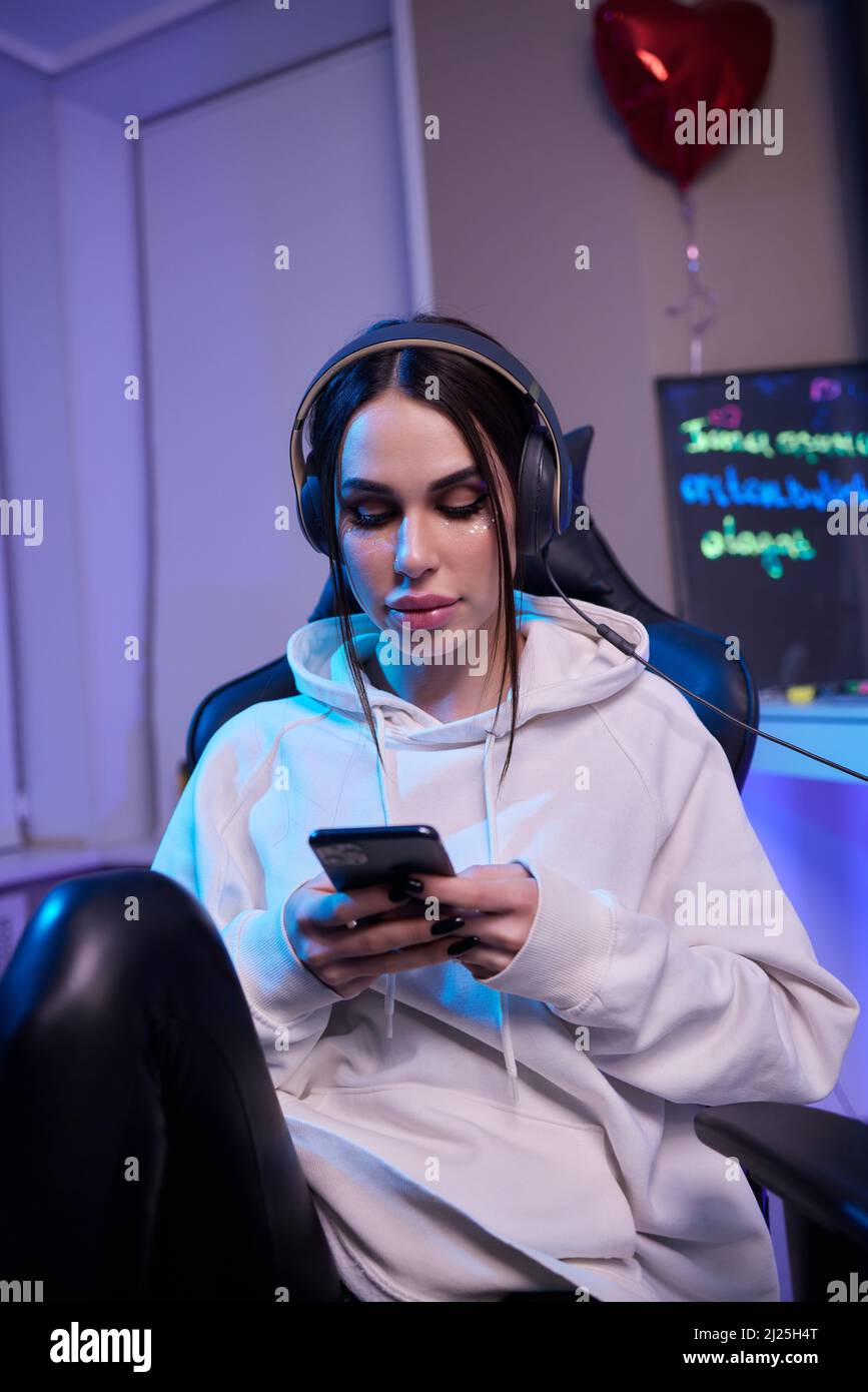 Happy woman putting on headphones and playing computer game. Female ...