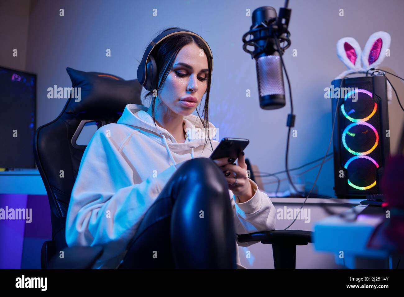 Happy woman putting on headphones and playing computer game. Female ...