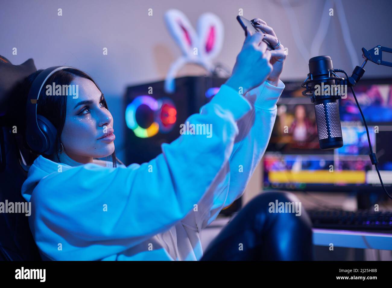 Happy woman putting on headphones and playing computer game. Female ...