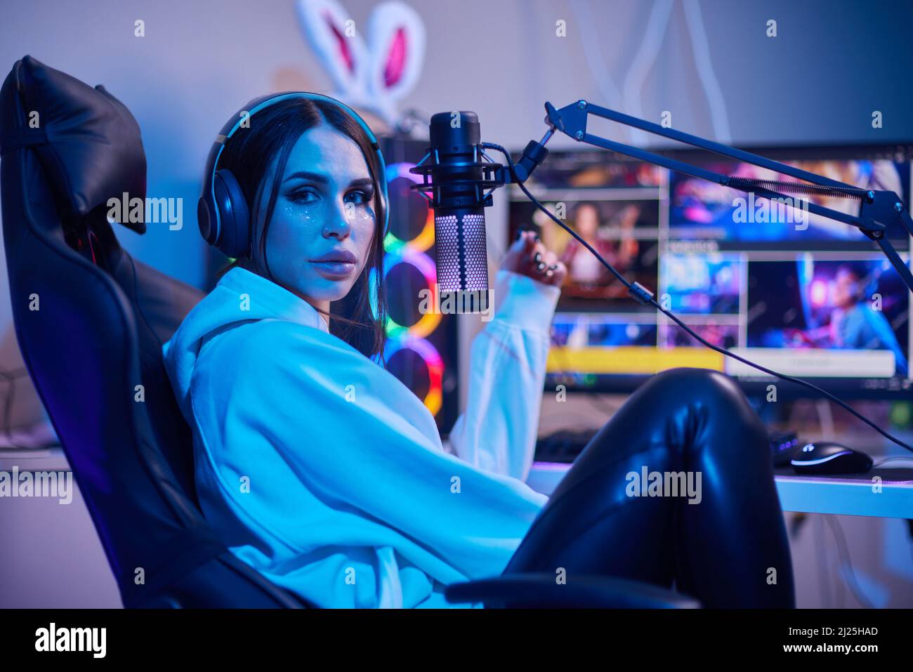 Happy woman putting on headphones and playing computer game. Female ...