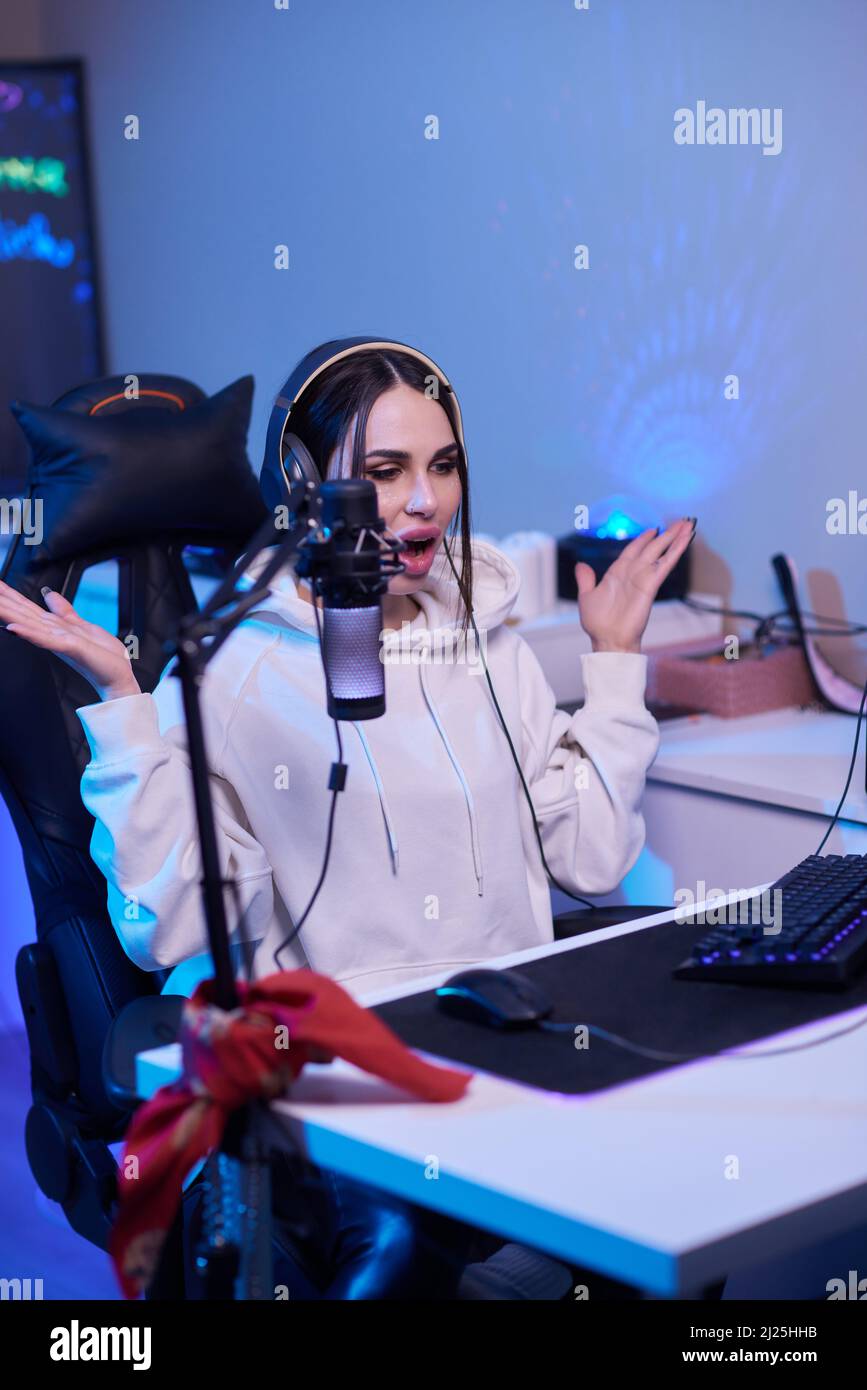 Happy woman putting on headphones and playing computer game. Female ...