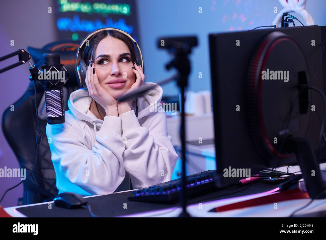Happy woman putting on headphones and playing computer game. Female ...