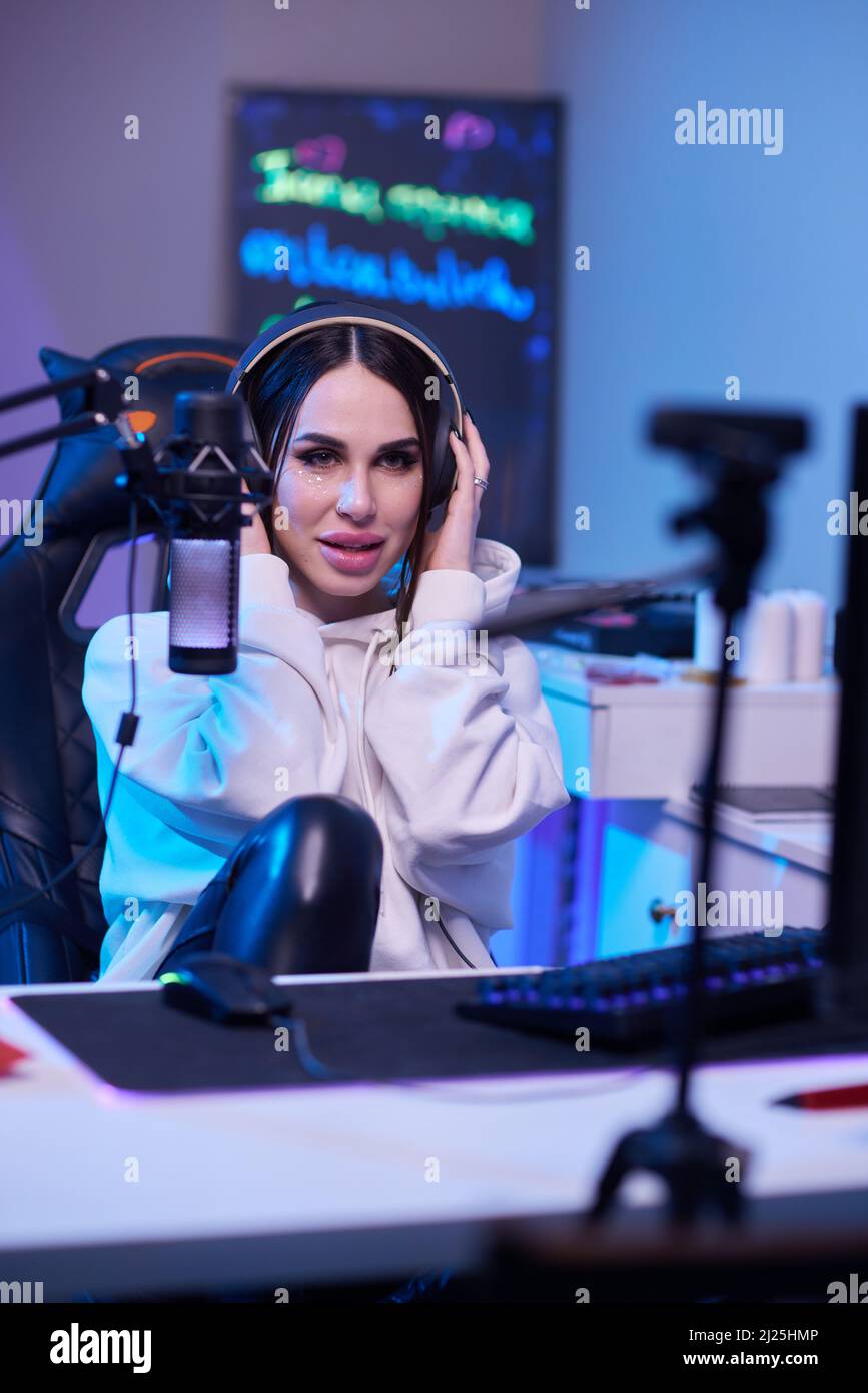 Happy woman putting on headphones and playing computer game. Female ...