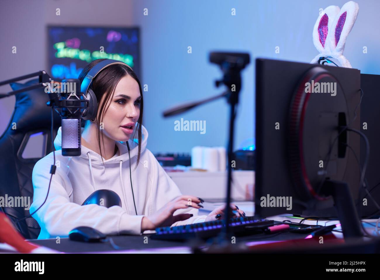 Happy woman putting on headphones and playing computer game. Female ...