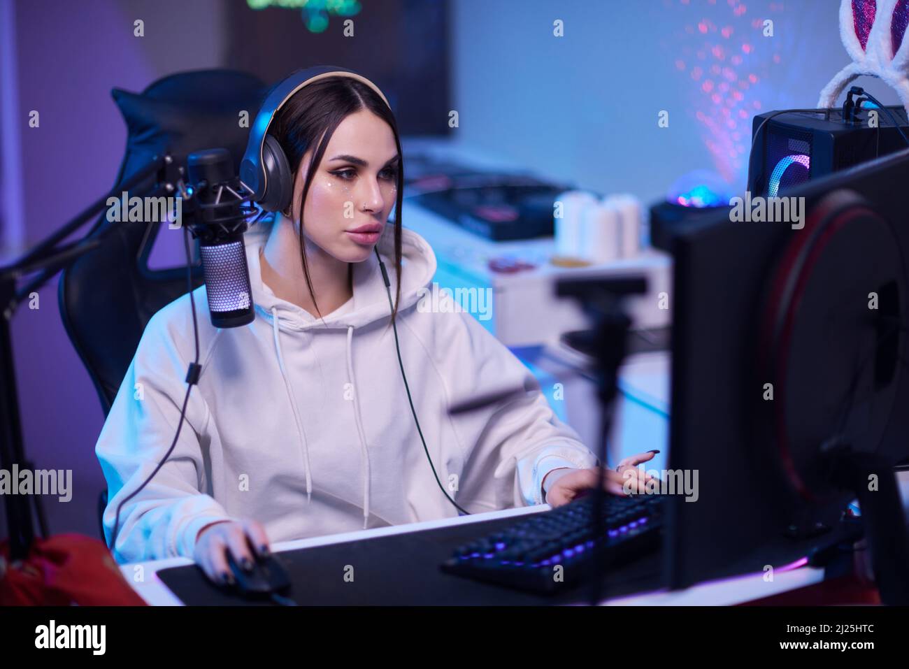 Happy woman putting on headphones and playing computer game. Female ...