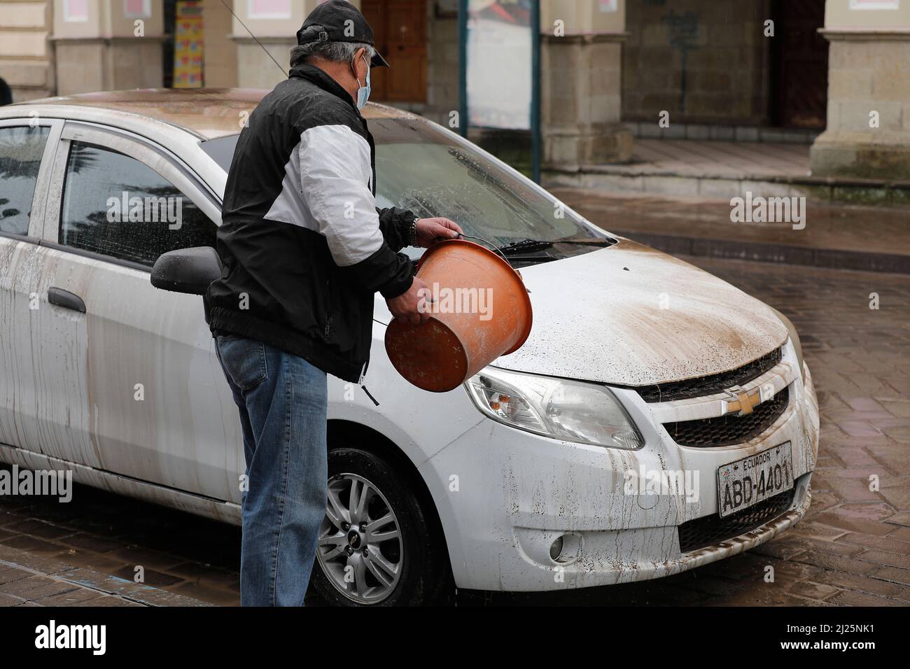 Man washing his car after a volcano spewed ash over Riobamba city ...