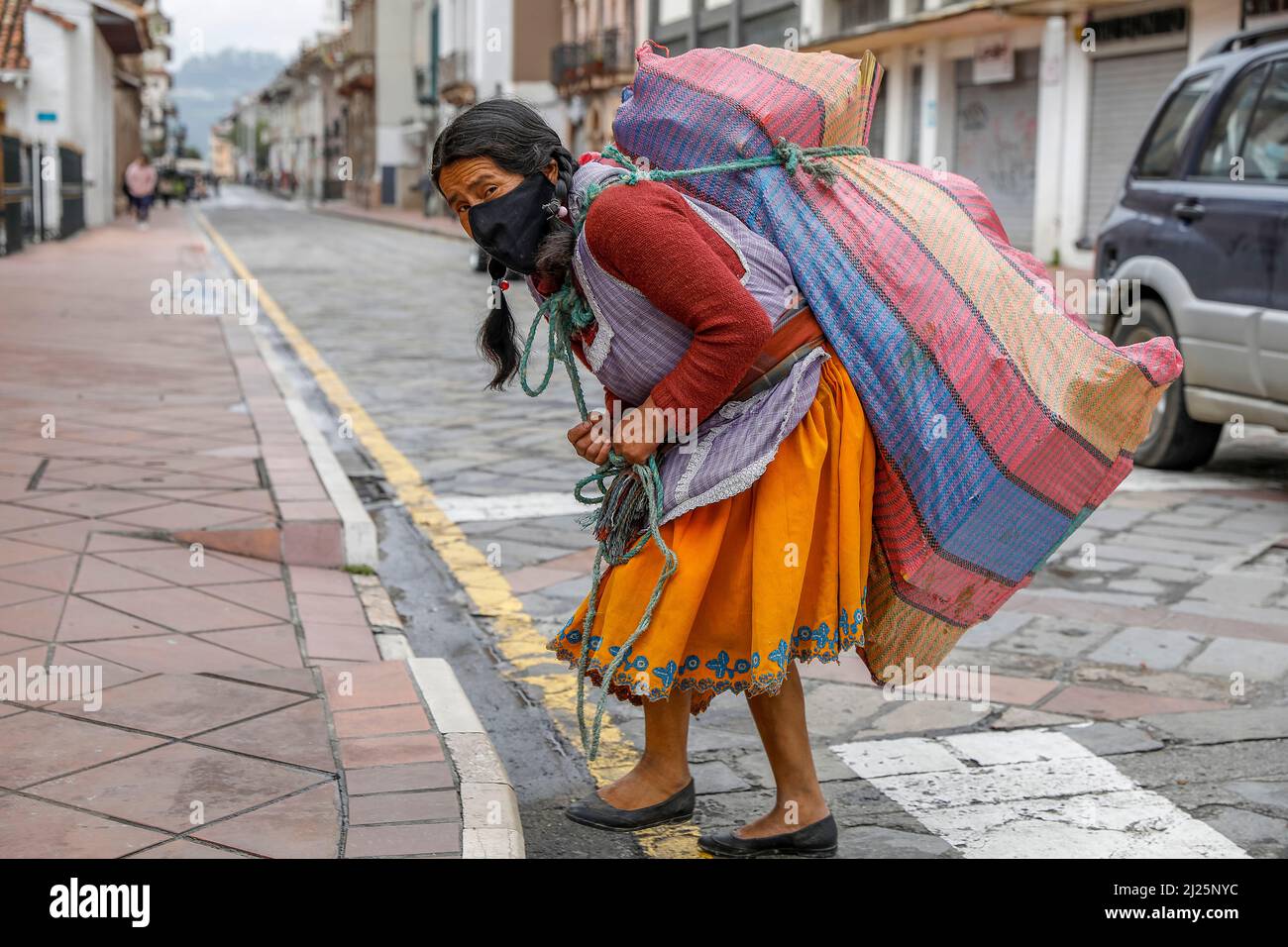 Indigenous woman carrying a big load in Cuenca, Ecuador Stock Photo - Alamy